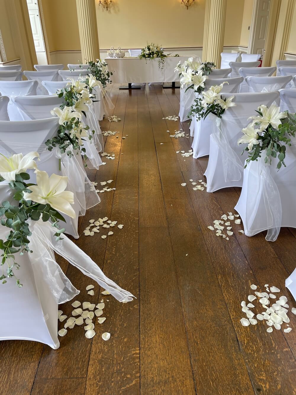 Tied chair ends of highly scented oriental lilies, line the aisleway at ...