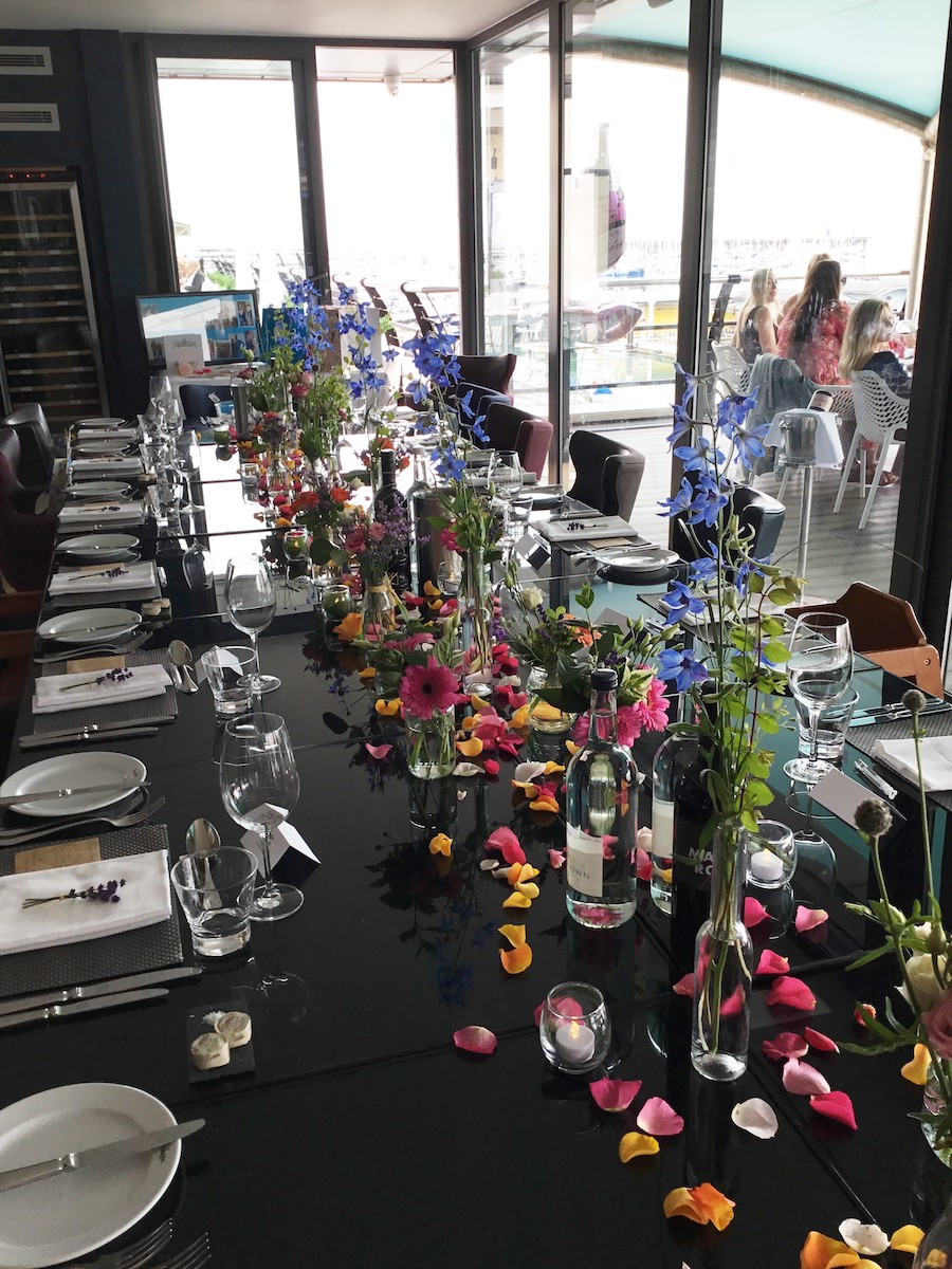 Tablescape of colourful flowers and scattered rose petals - Brighton ...